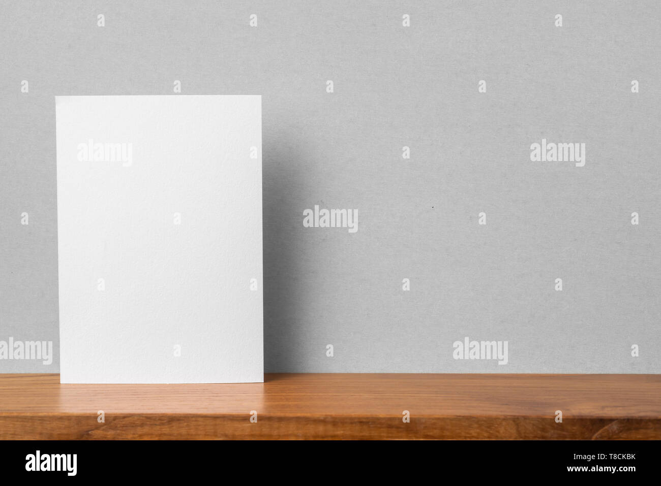 Design concept - front view of A4 paper on bookshelf and grey wall for ...