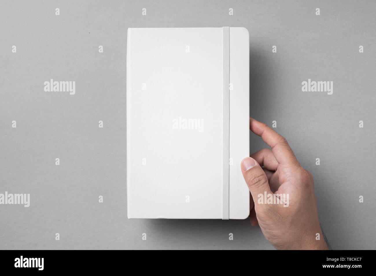 Design concept - top view of close white notebook hold by mans hand on ...