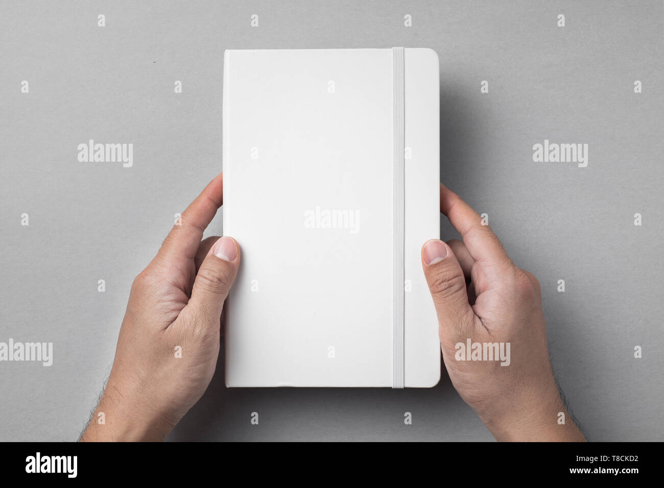 Design concept - top view of close white notebook hold by mans hand on ...