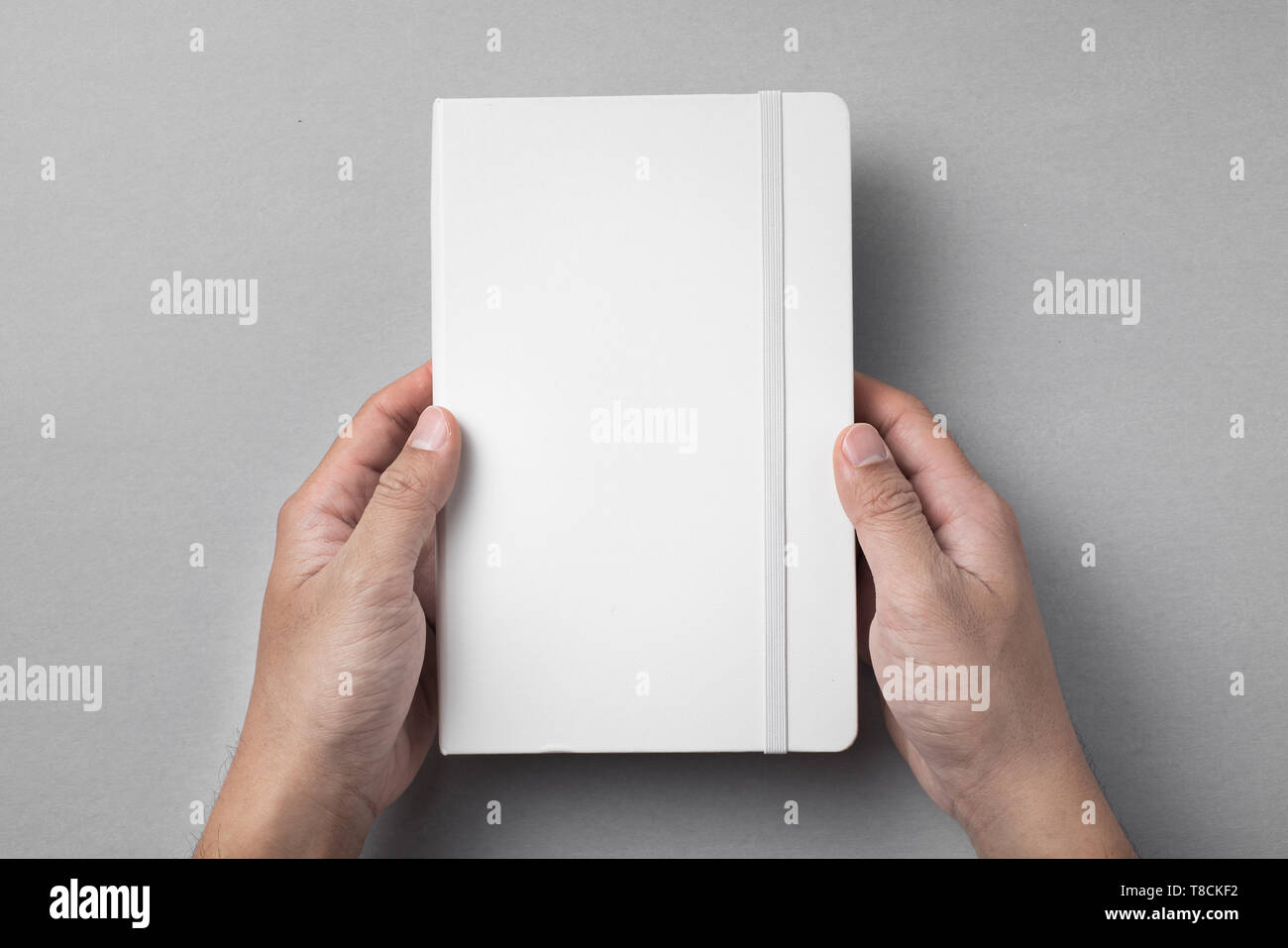 Design concept - top view of close white notebook hold by mans hand on ...
