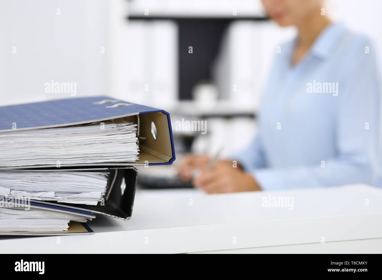 Calculator and binders with papers are waiting to be processed by ...