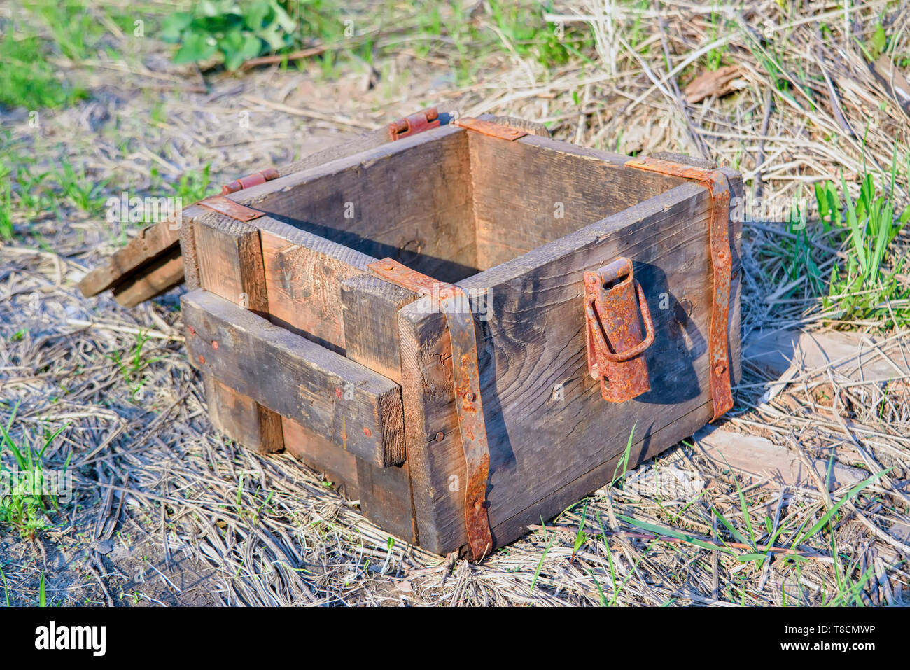 An antique wooden box with rusty metal hardware fittings rests on a ...