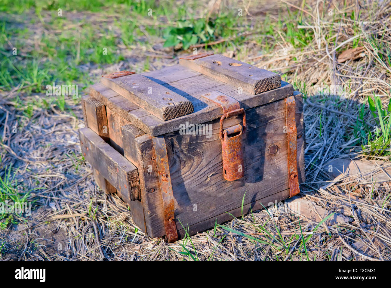 An antique wooden box with rusty metal hardware fittings rests on a ...