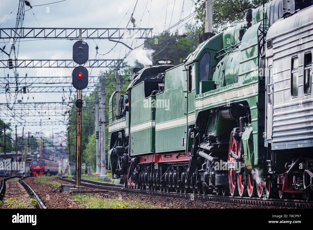 Retro steam train approaches to the station Stock Photo - Alamy