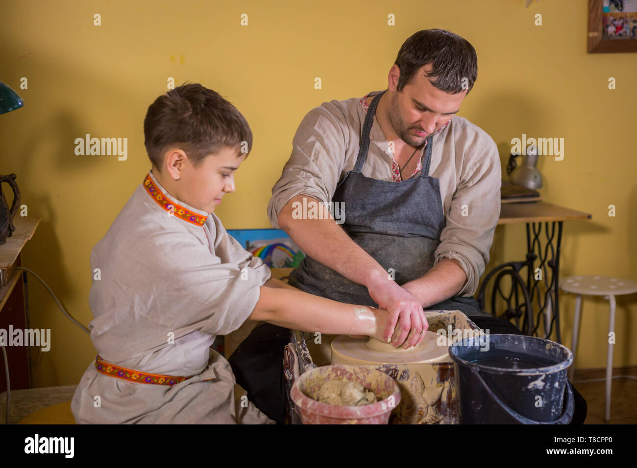 Pottery class and workshop: professional male potter working with boy ...