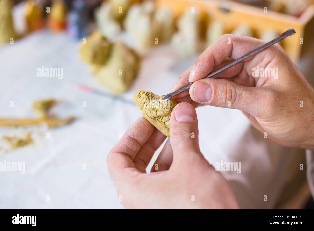 Professional male potter making clay figure for medieval popular ...