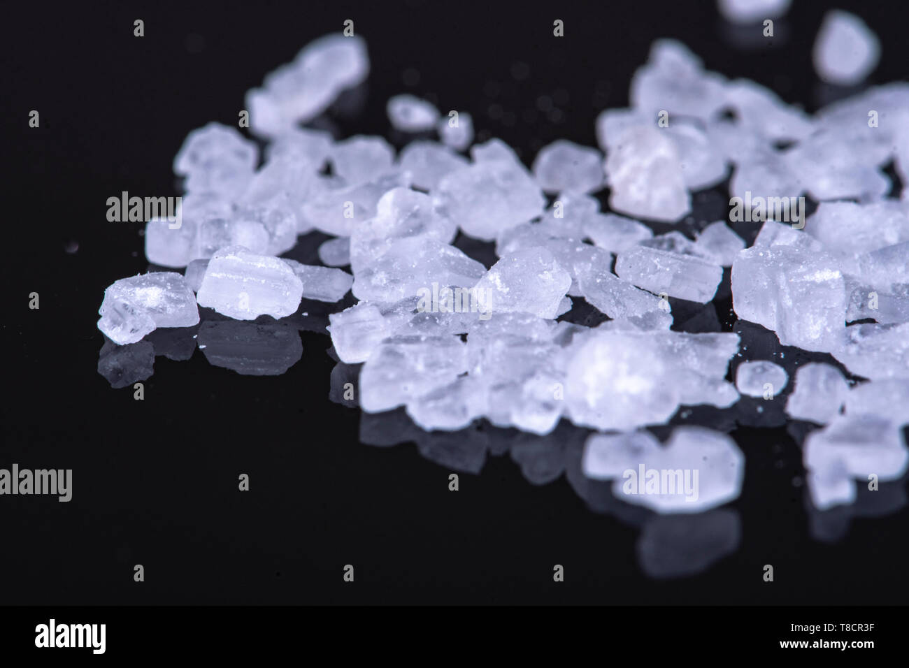 coarse salt crystals on a black background in one group Stock Photo - Alamy