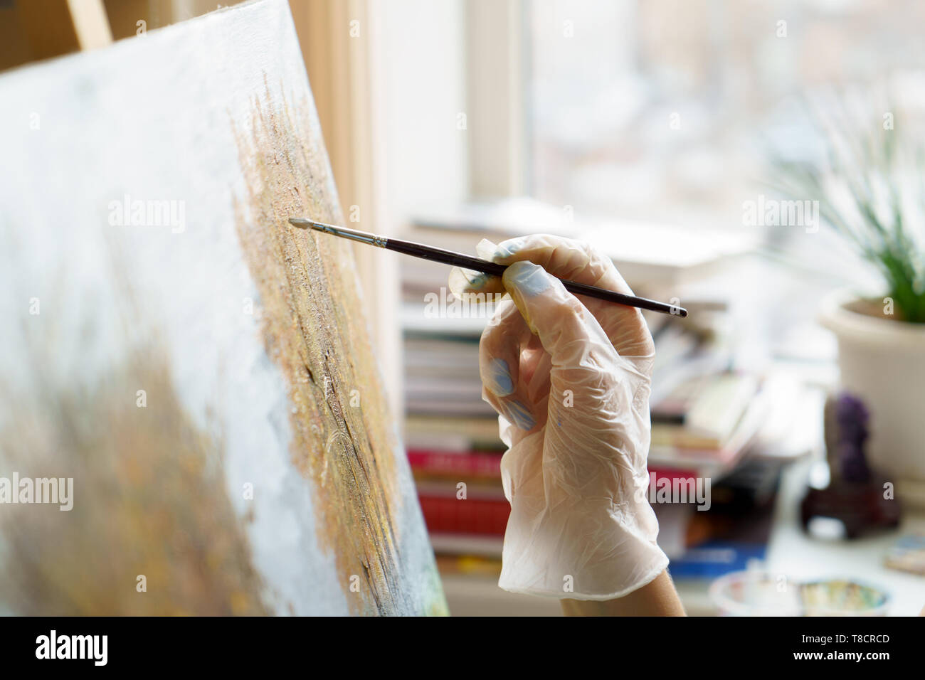 artist's hand in glove draws with an oil painting with a brush close-up ...