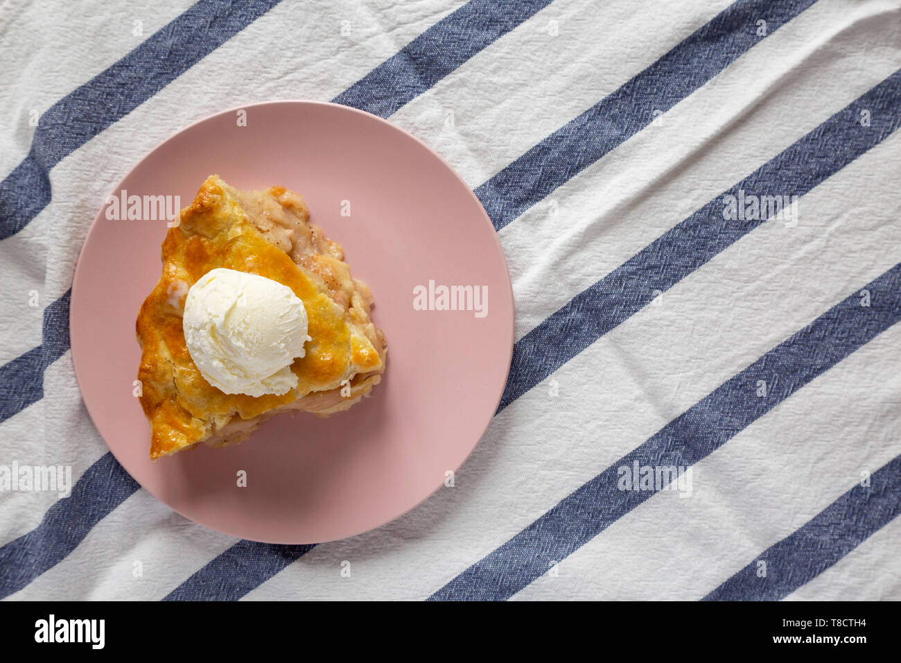 Slice of homemade apple pie with ice cream on a pink plate, view from ...