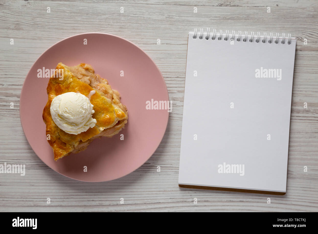 Slice of homemade apple pie with ice cream on a pink plate, blank ...