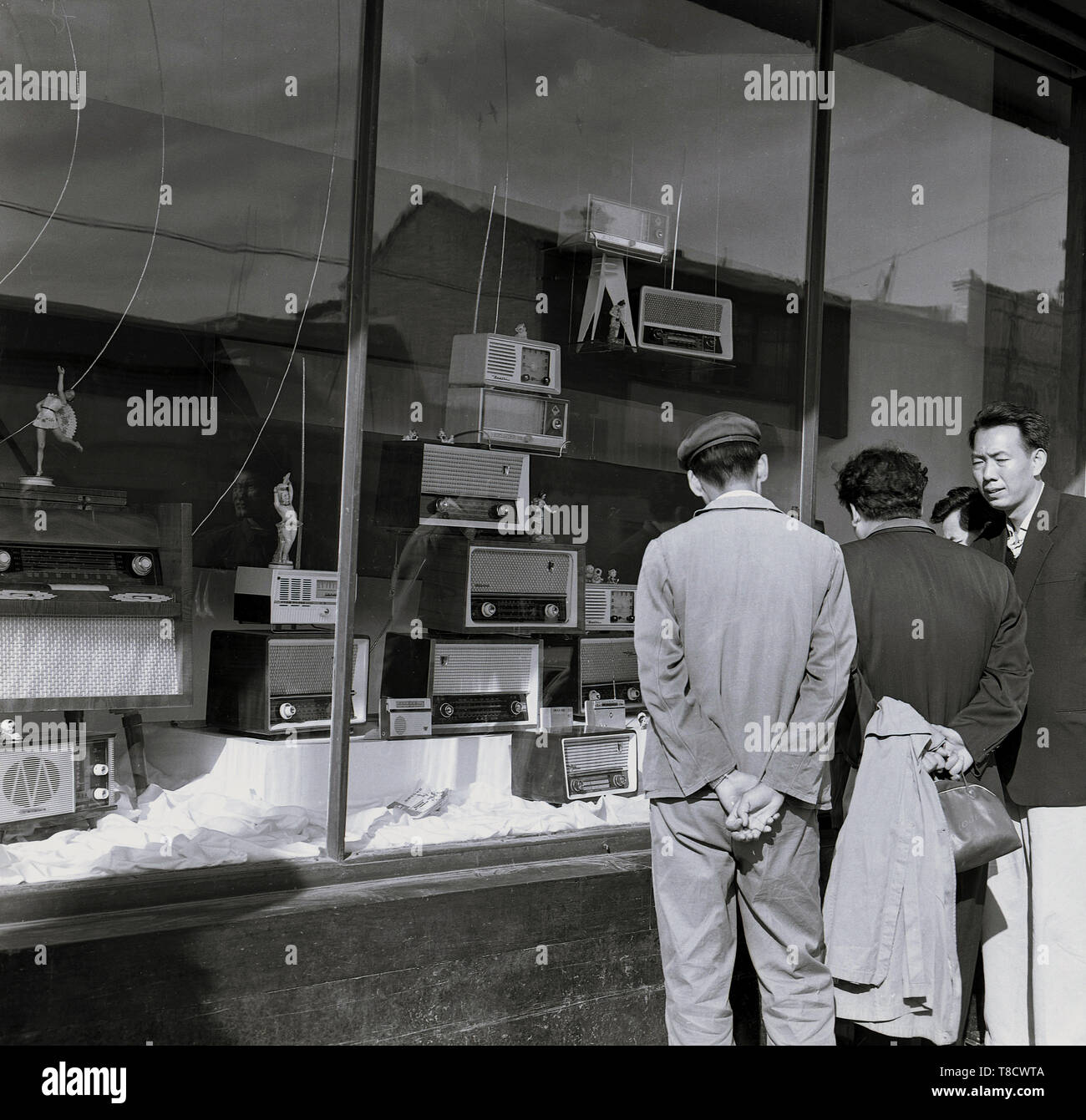 1950s, historical, chinese people looking at a store window showing the ...