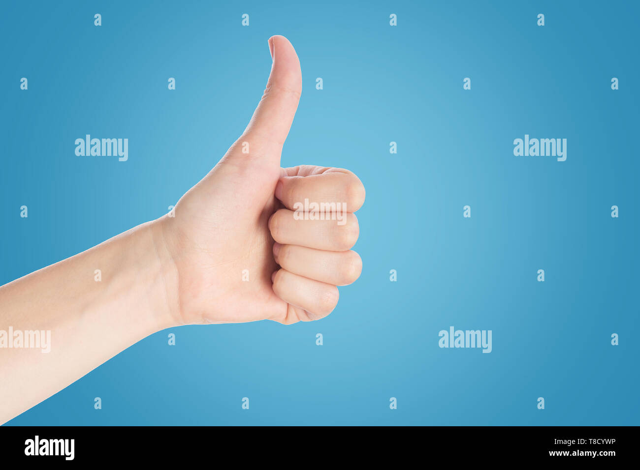 Positive gesture on blue background. Hand show thumbs up sign, close up ...