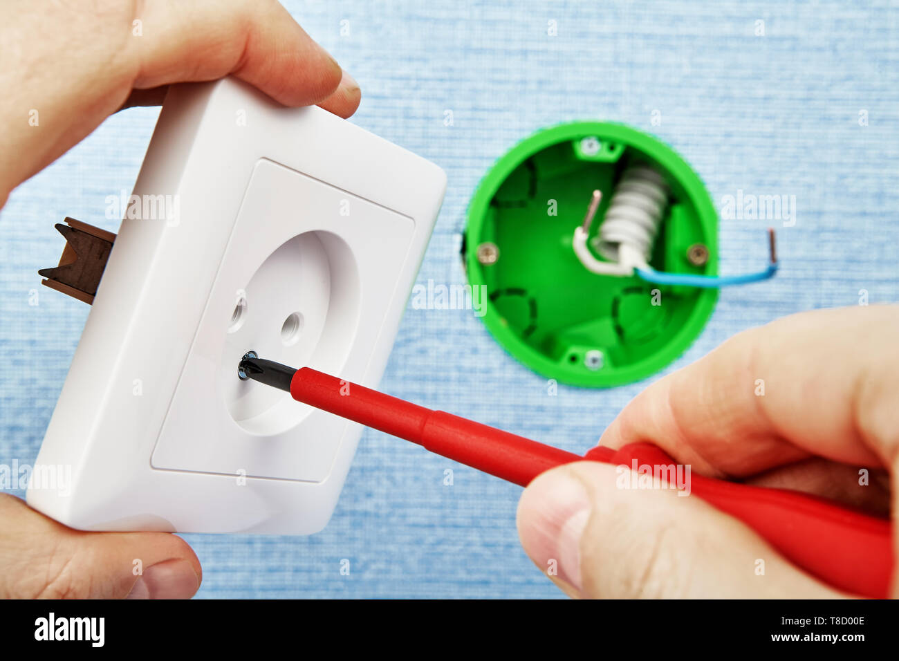 Worker is twisting screw in new european standard socket with hand tool ...