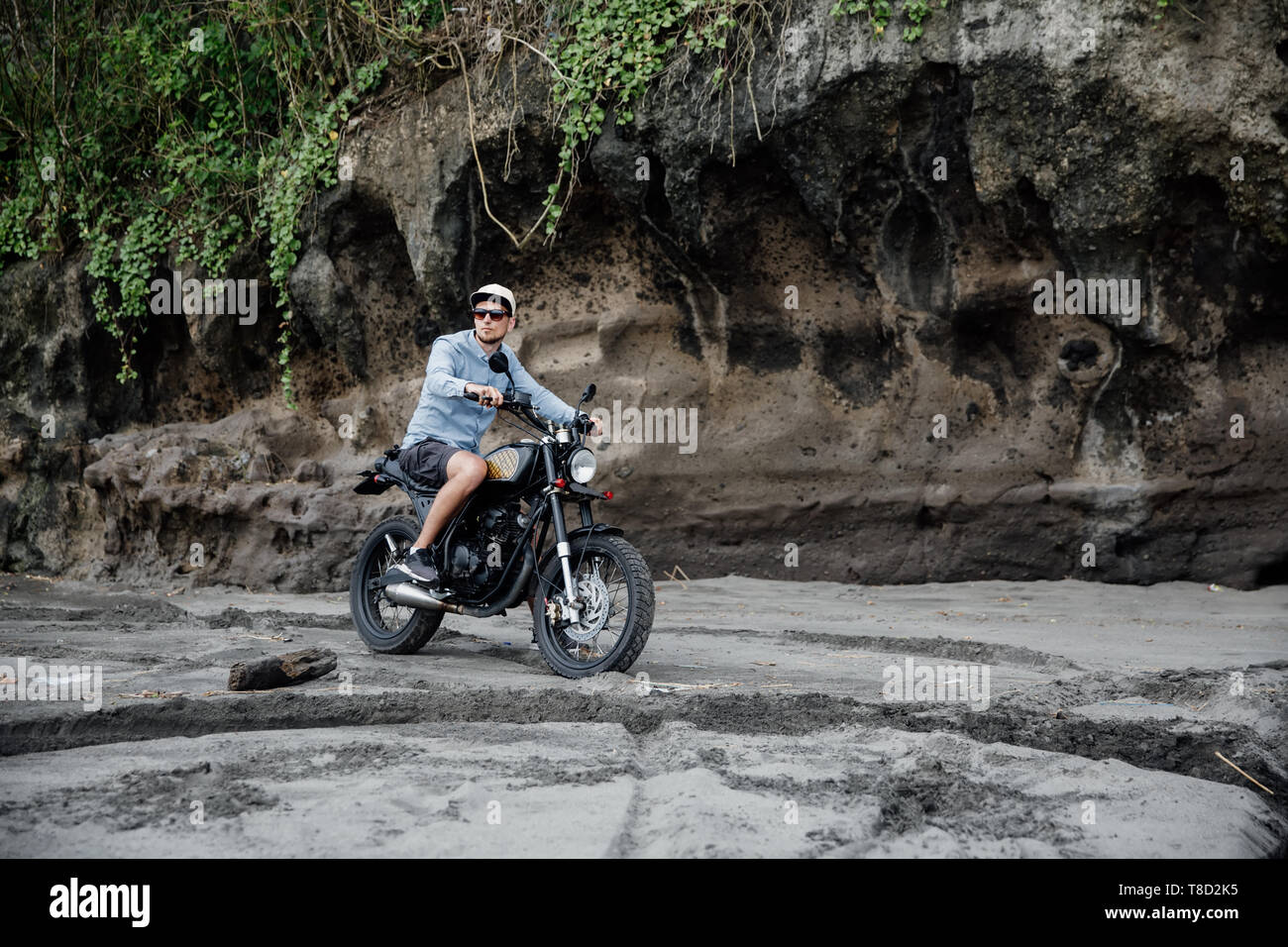 Man in cap riding motorcycle on beach. Moto cross dirtbiker on beach ...