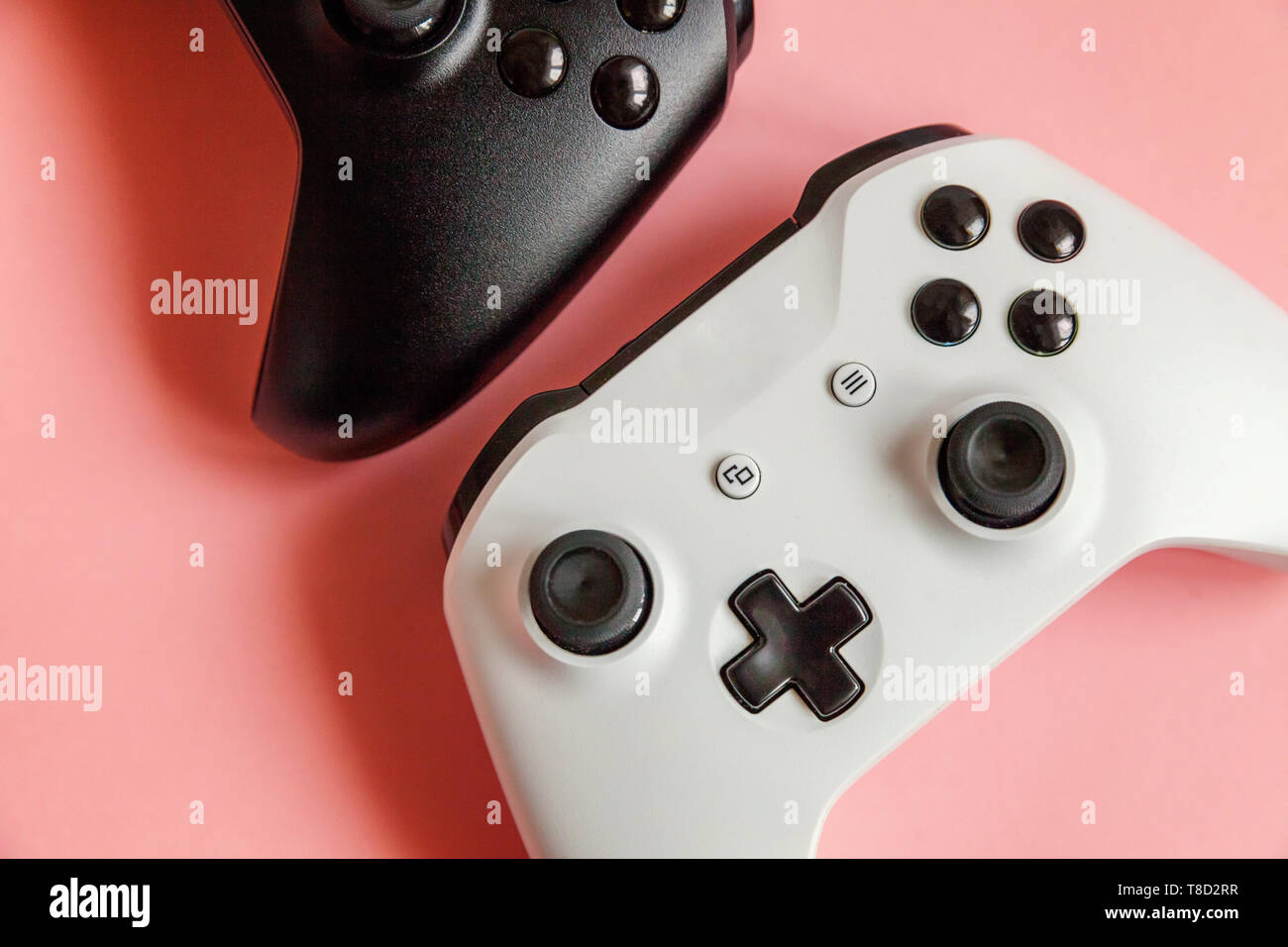 White and black two joystick gamepad, game console on pastel pink ...