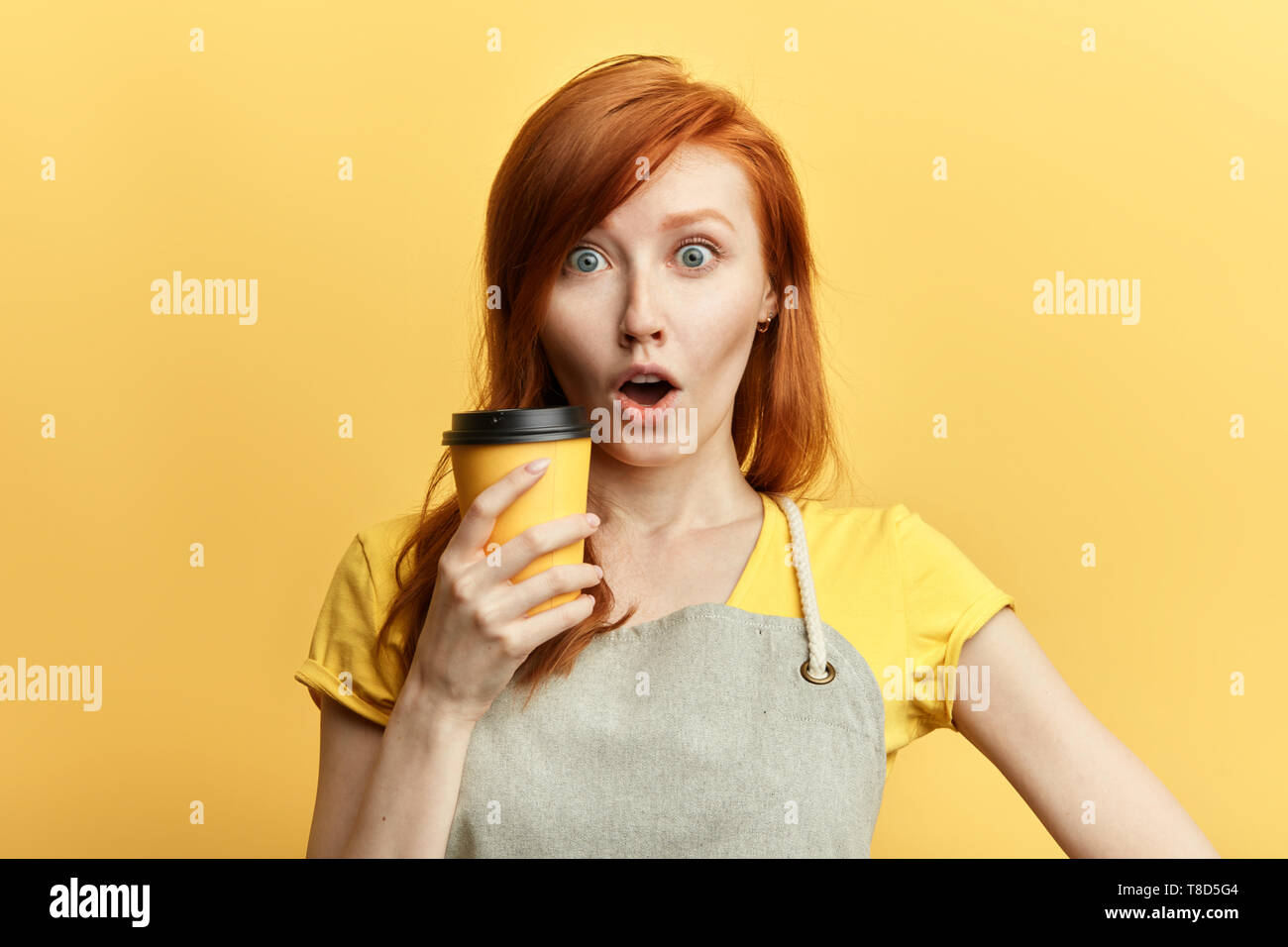 surprised puzzled emotional girl with wide open mouth holding a paper ...