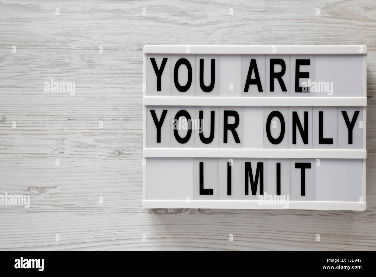'You are your only limit' words on a modern board over white wooden ...