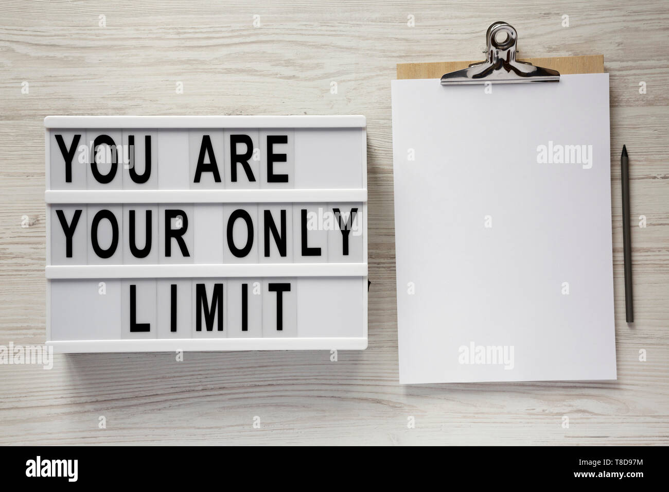 'You are your only limit' words on a lightbox, clipboard with blank ...