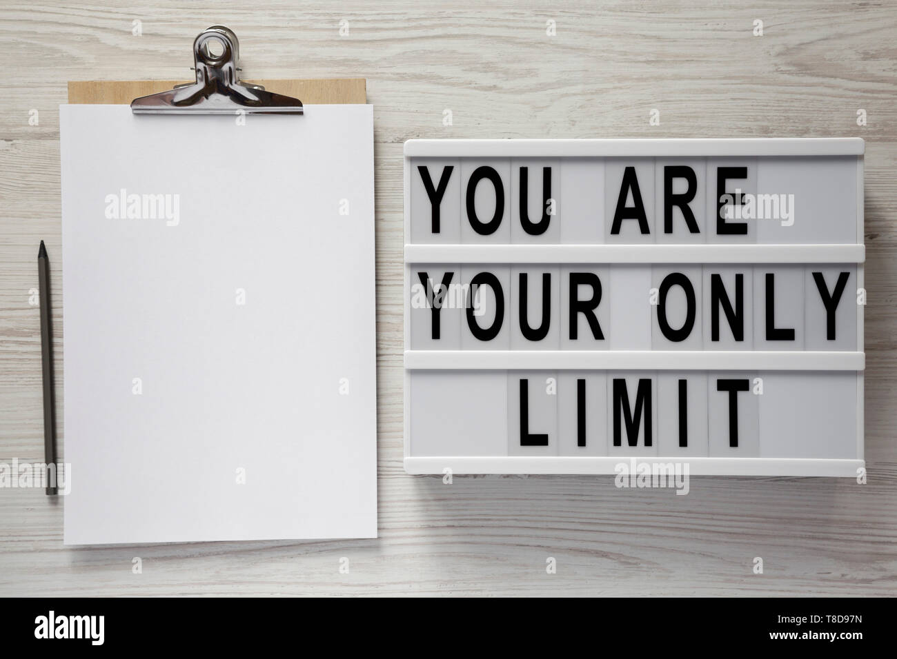 'You are your only limit' words on a lightbox, clipboard with blank ...