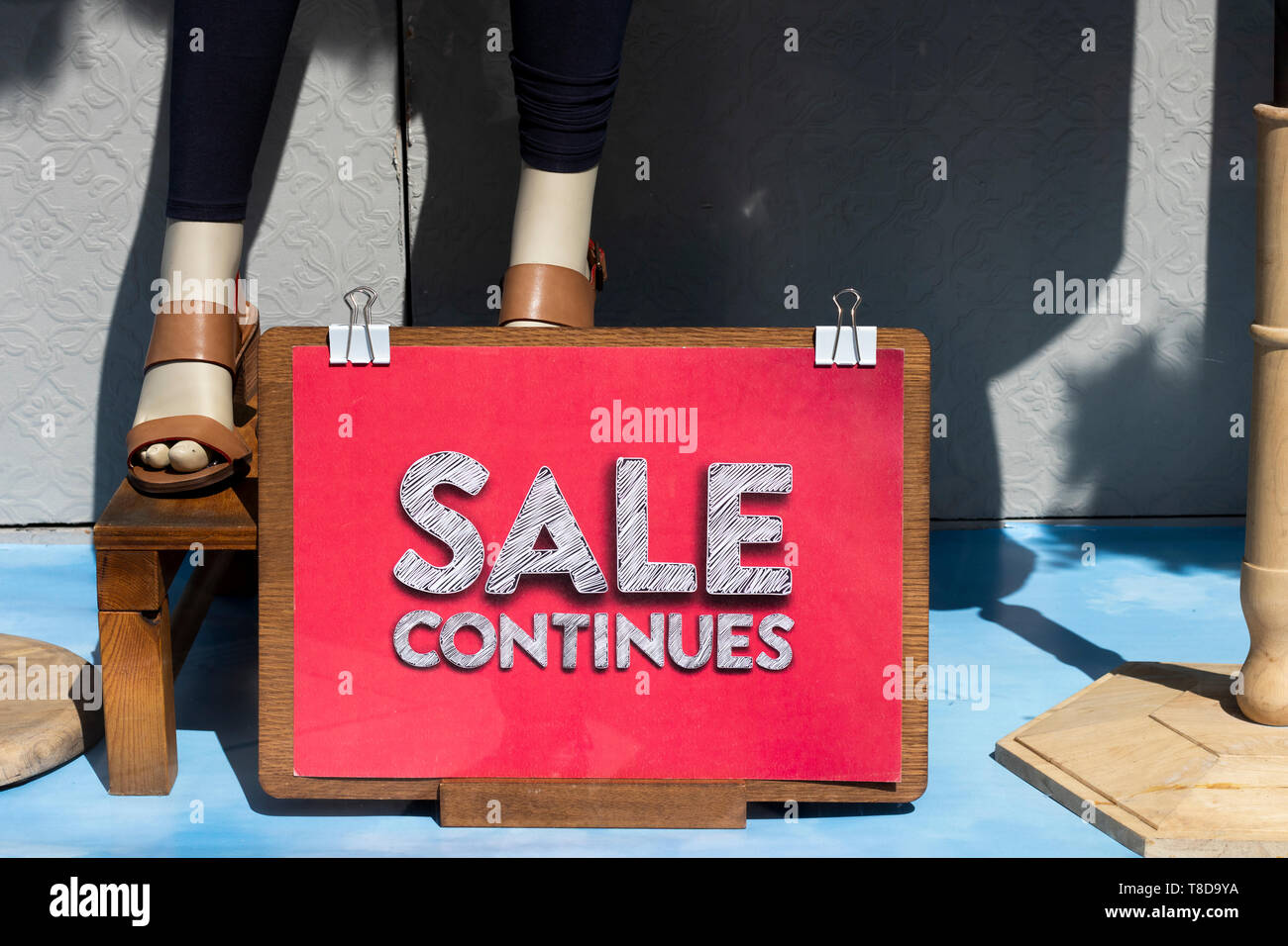 sale continues sign in womenswear store shop window Stock Photo - Alamy