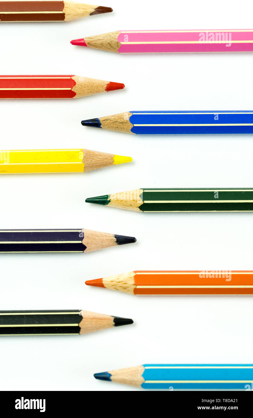 vertical view of colored pencils facing each other on a white ...