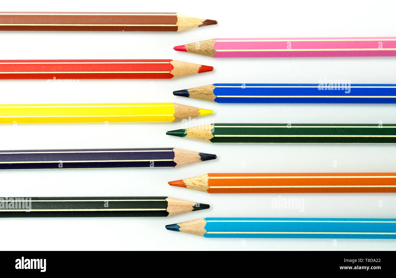 horizontal view of colored pencils facing each other on a white ...