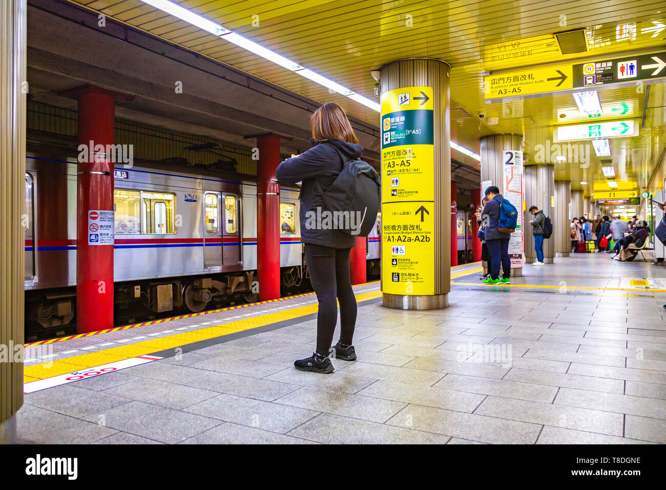 Tokyo, Japan - 24 April 2019 - Commuters wait for the subway train at a ...