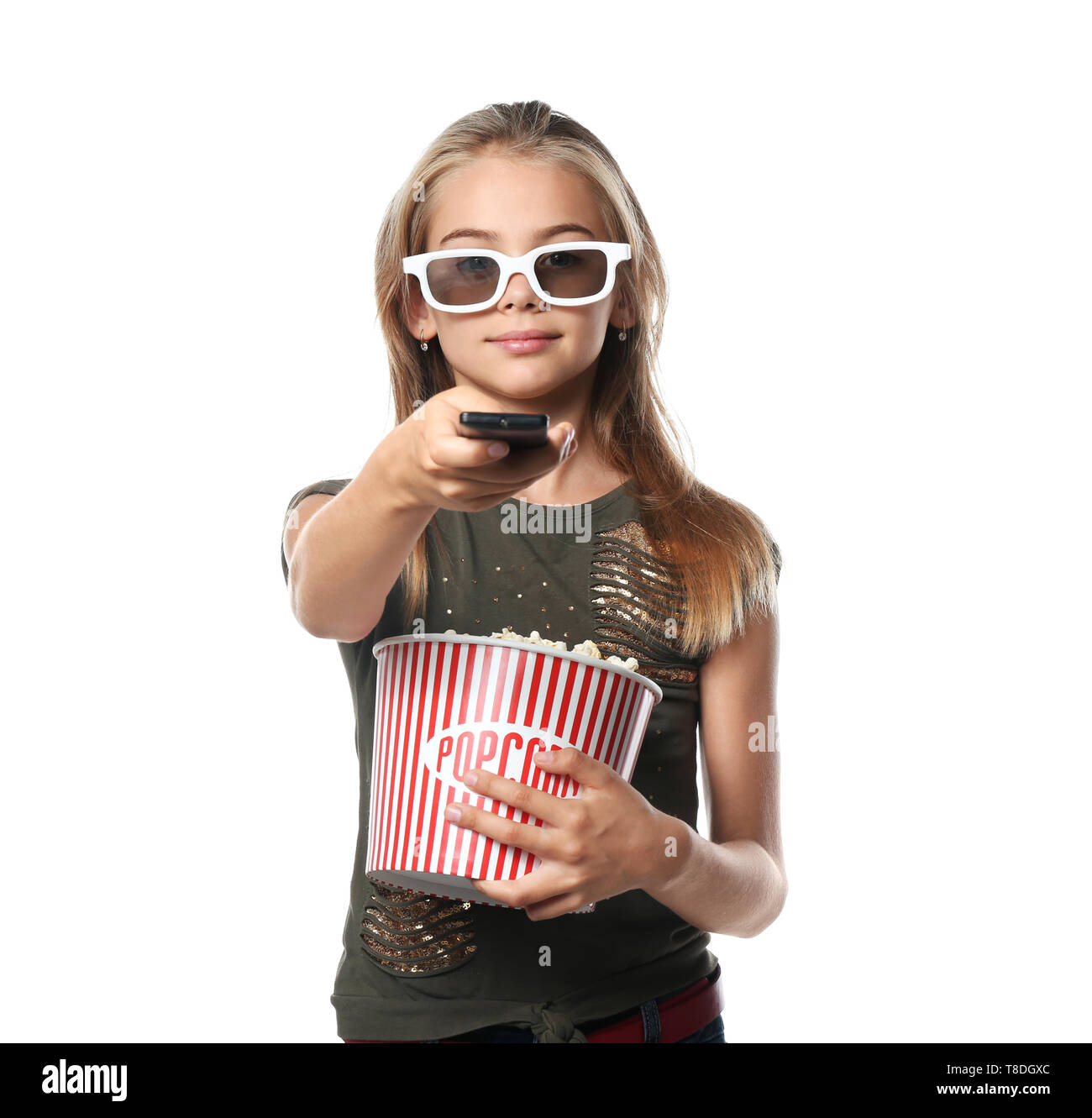 Cute little girl with cup of popcorn switching channels on white ...