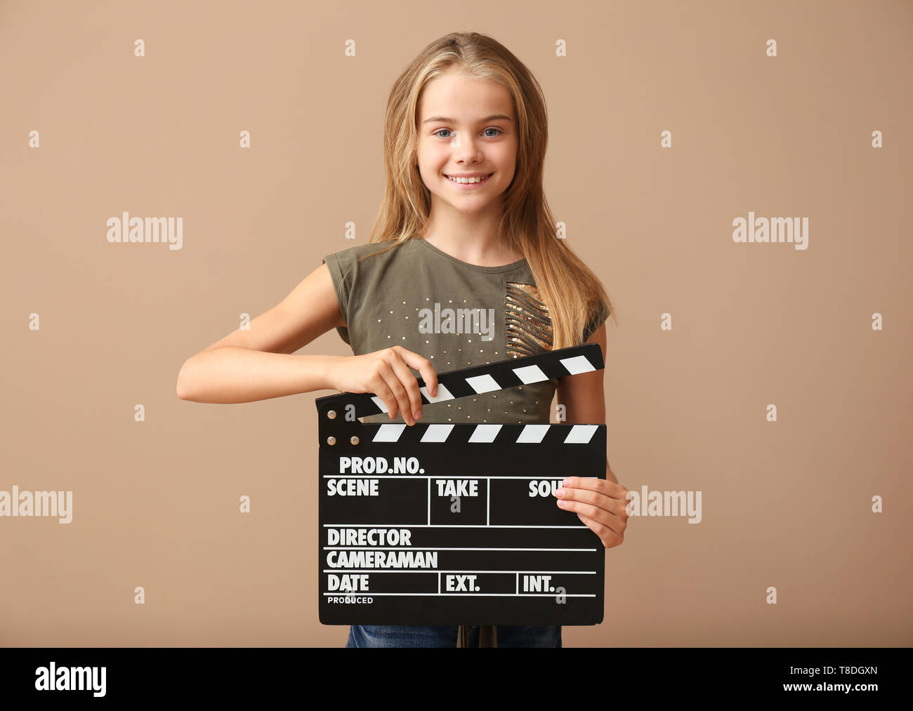 Cute little girl with clapper board on color background Stock Photo - Alamy