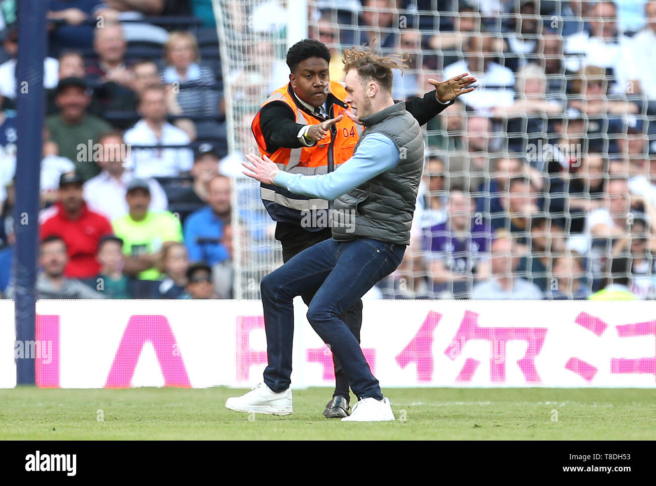 Steward apprehends a pitch invader during the Premier League match at ...