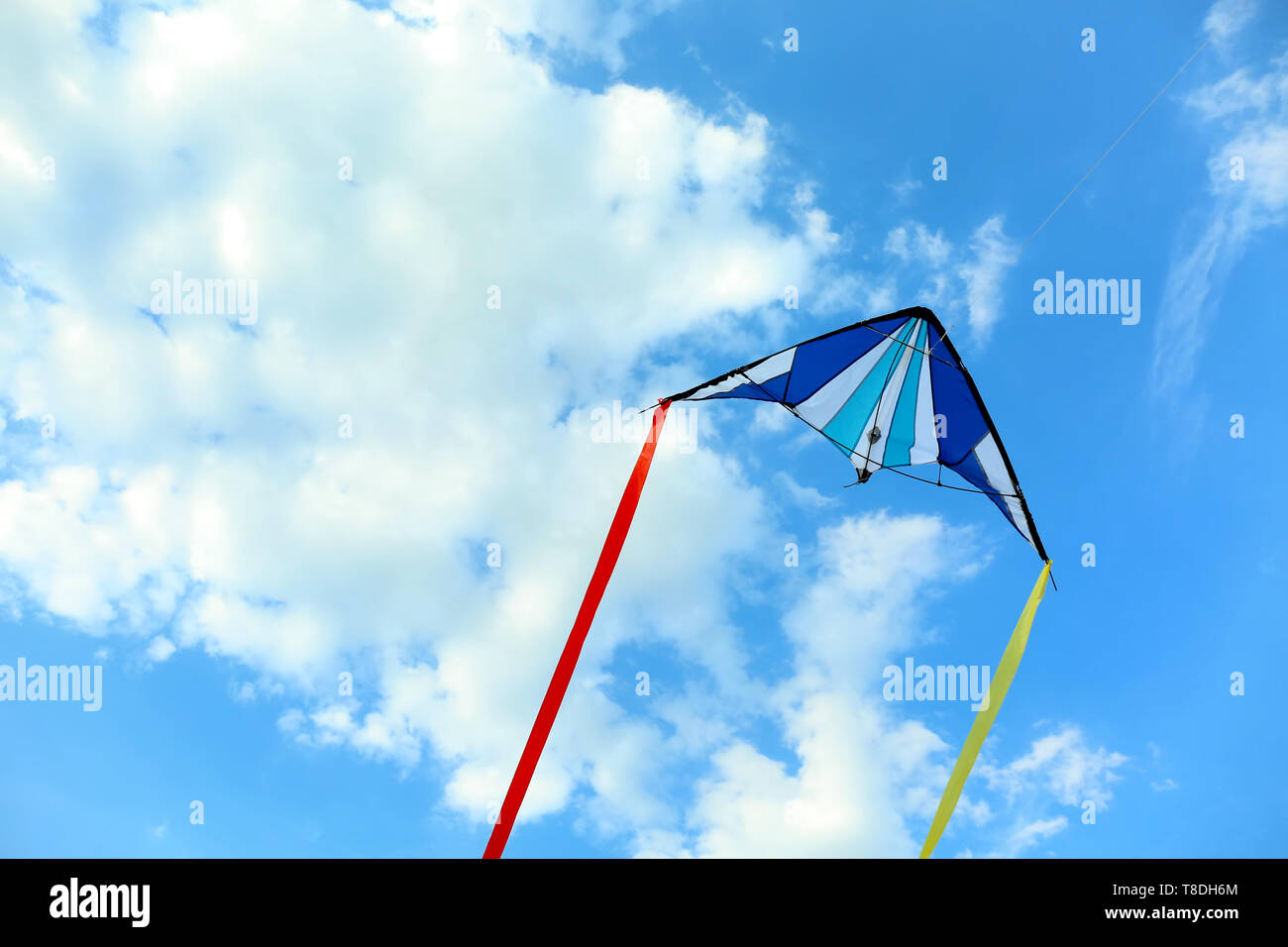 Colorful kite flying in blue sky Stock Photo - Alamy