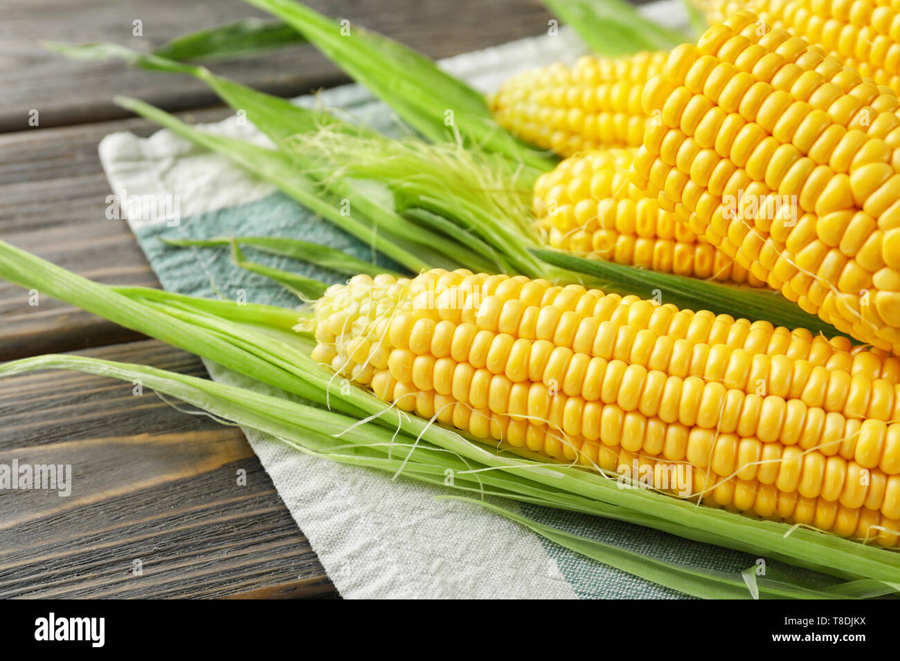 Fresh corn cobs on wooden background, closeup Stock Photo - Alamy