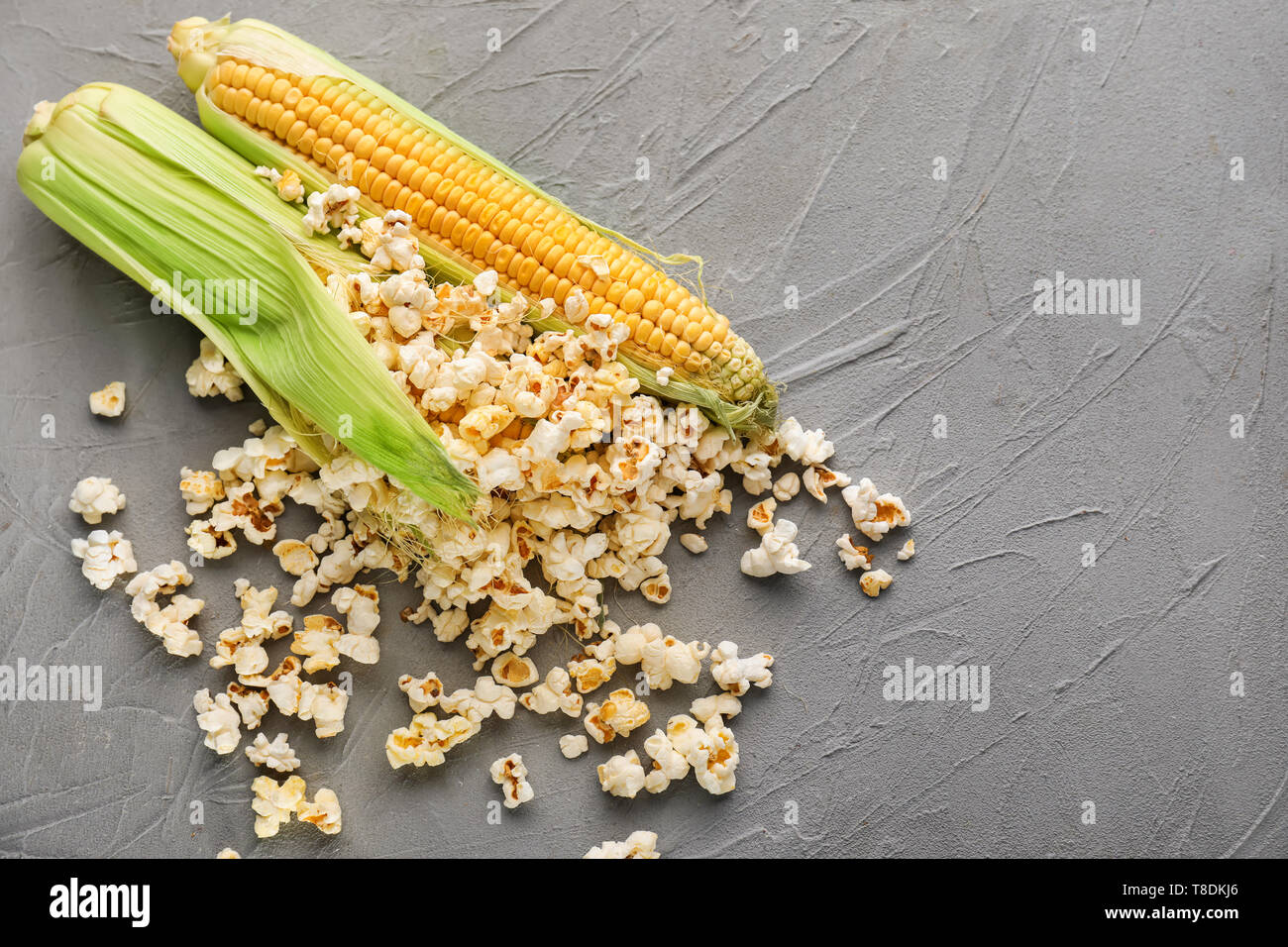 Delicious popcorn and cobs on grey background Stock Photo - Alamy