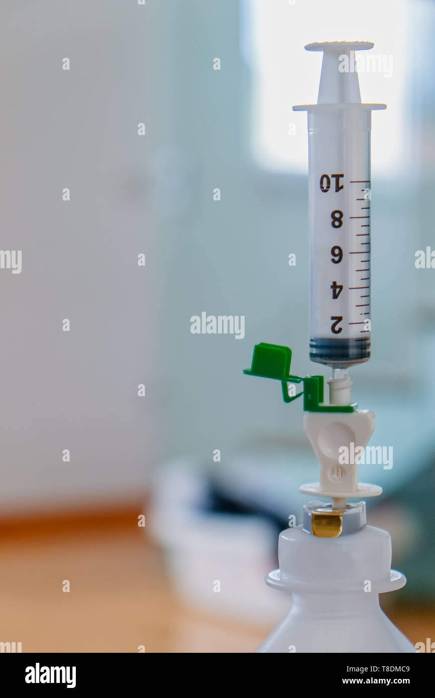 Medical syringe in the vial, defocused background, medical and ...