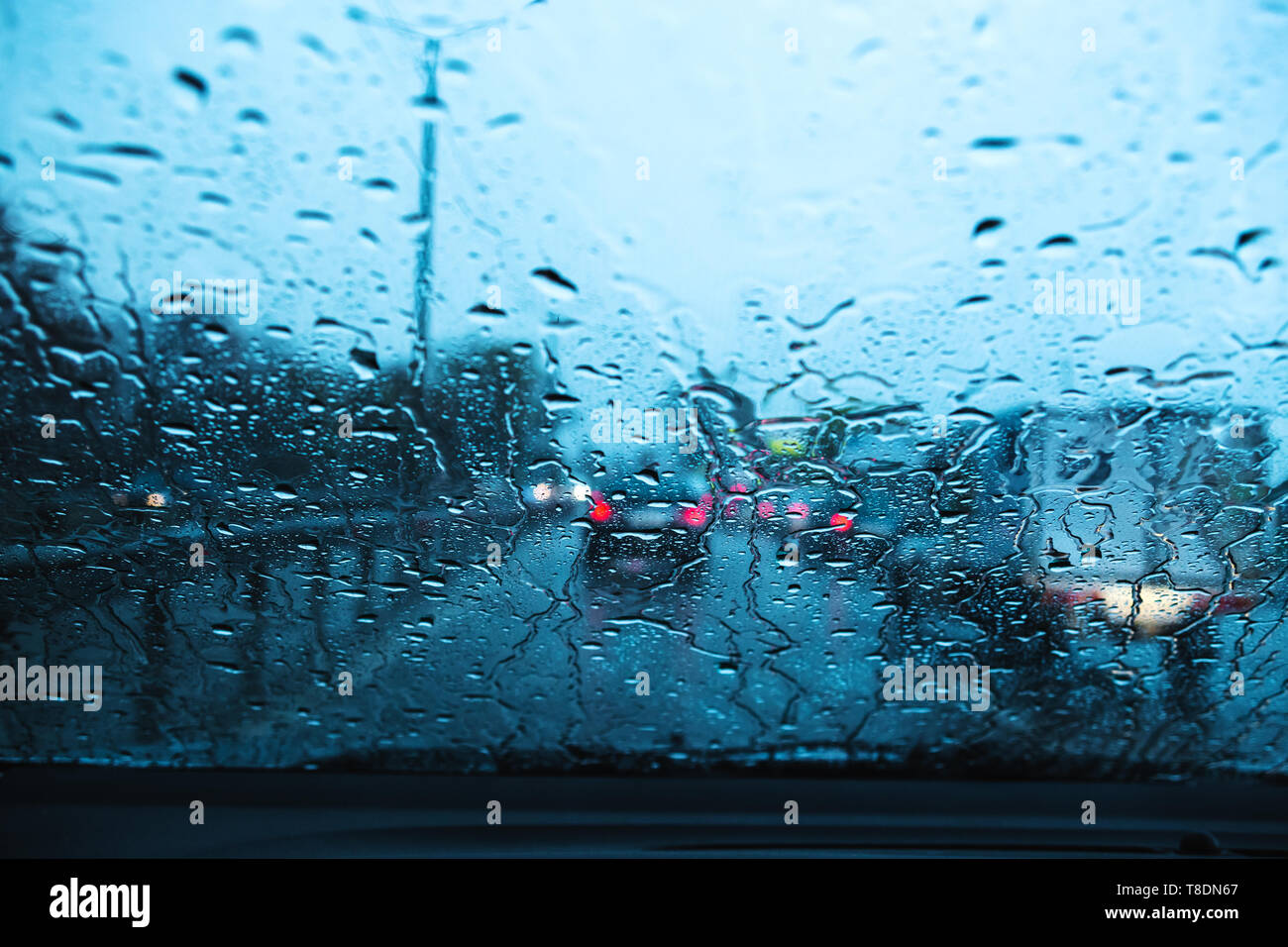 City road through windshield cars abstract background water drop on the ...