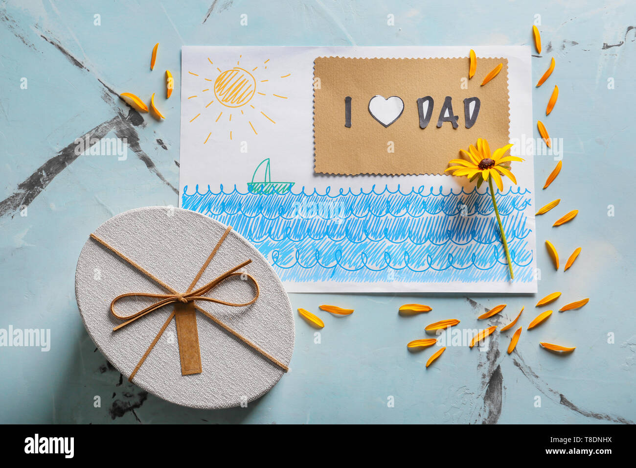 Gift box, child's drawing and "I LOVE DAD" greeting card on color ...