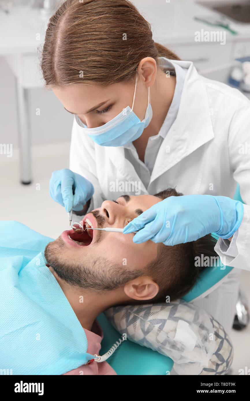 Dentist examining patient's teeth in clinic Stock Photo - Alamy