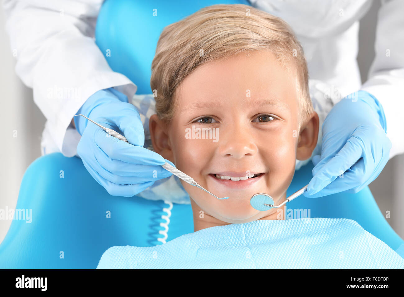 Dentist examining little boy's teeth in clinic Stock Photo - Alamy