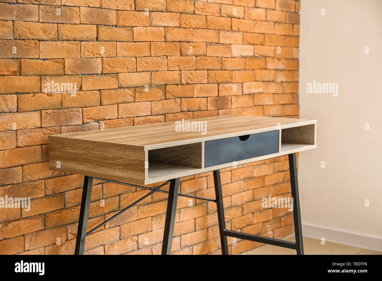 Table near brick wall Stock Photo - Alamy