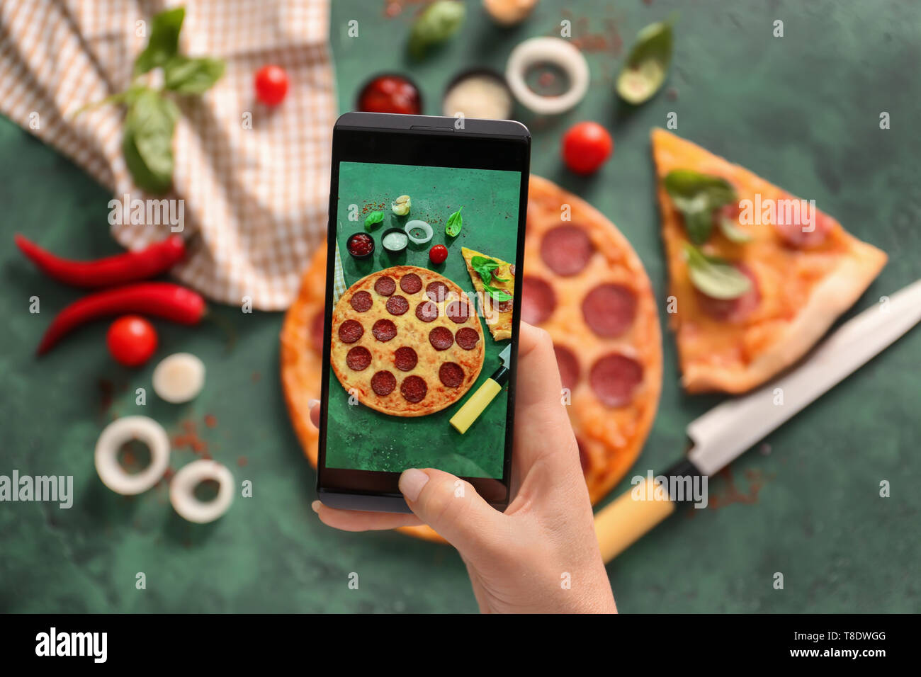 Woman taking photo of tasty Pepperoni pizza on table Stock Photo - Alamy