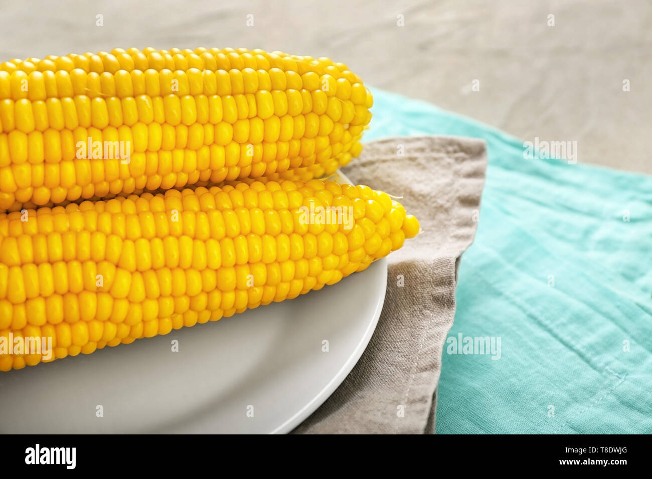 Plate with tasty corn cobs on table, closeup Stock Photo - Alamy