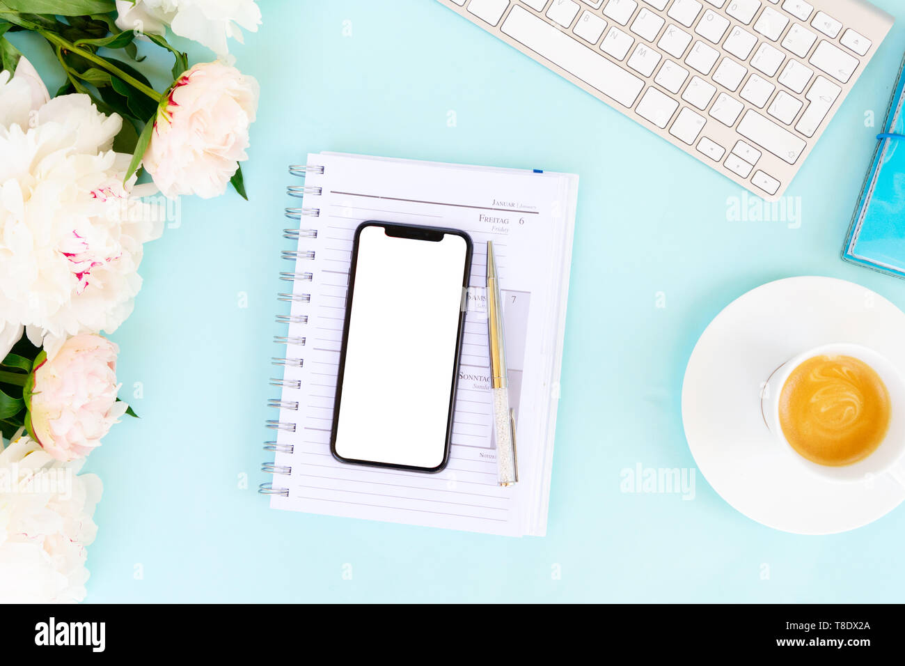 Home office desk with phone on blue Stock Photo - Alamy