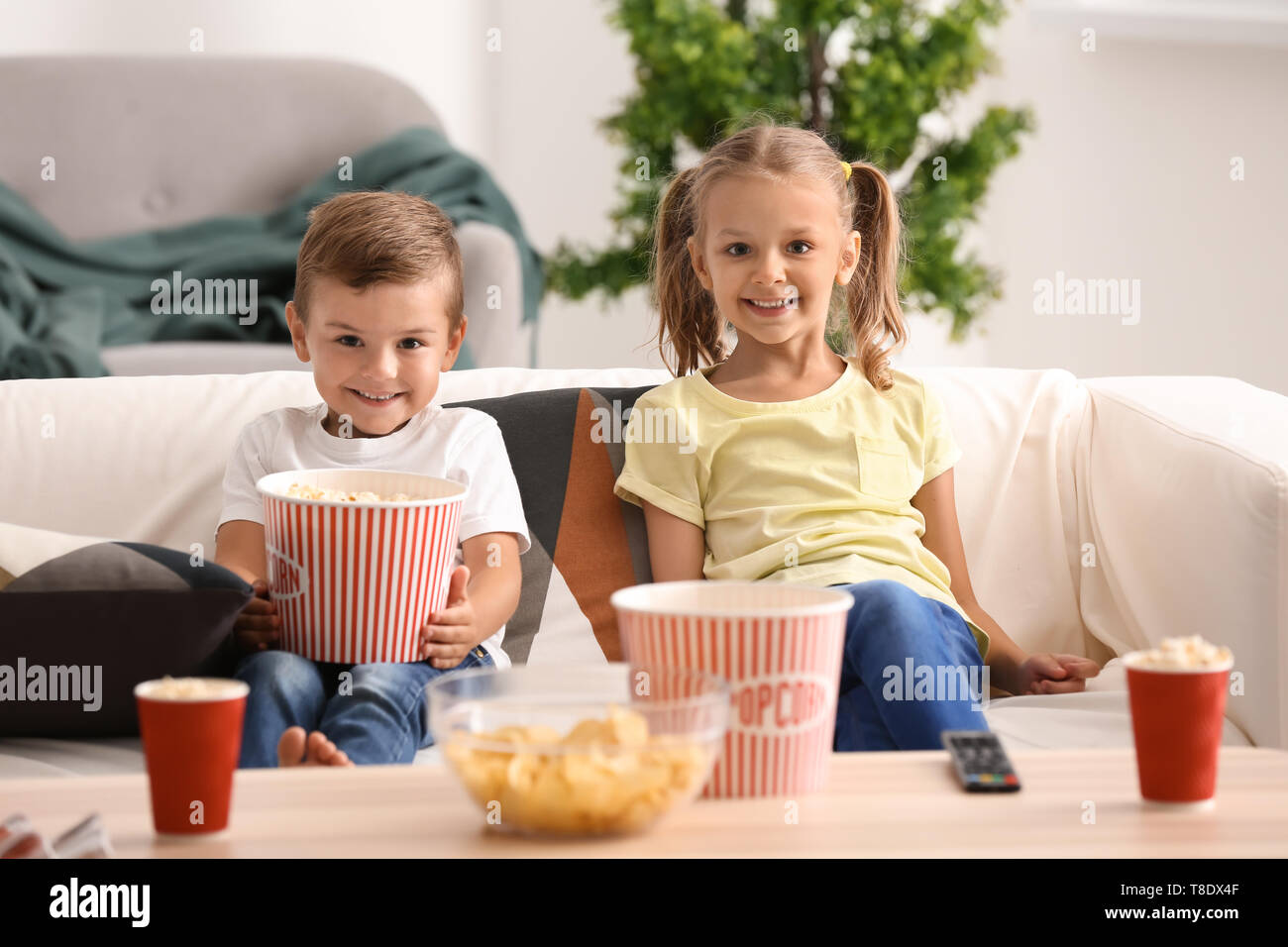 Cute children eating popcorn while watching TV at home Stock Photo - Alamy Cute children eating popcorn while watching TV at home Stock Photo - Alamy