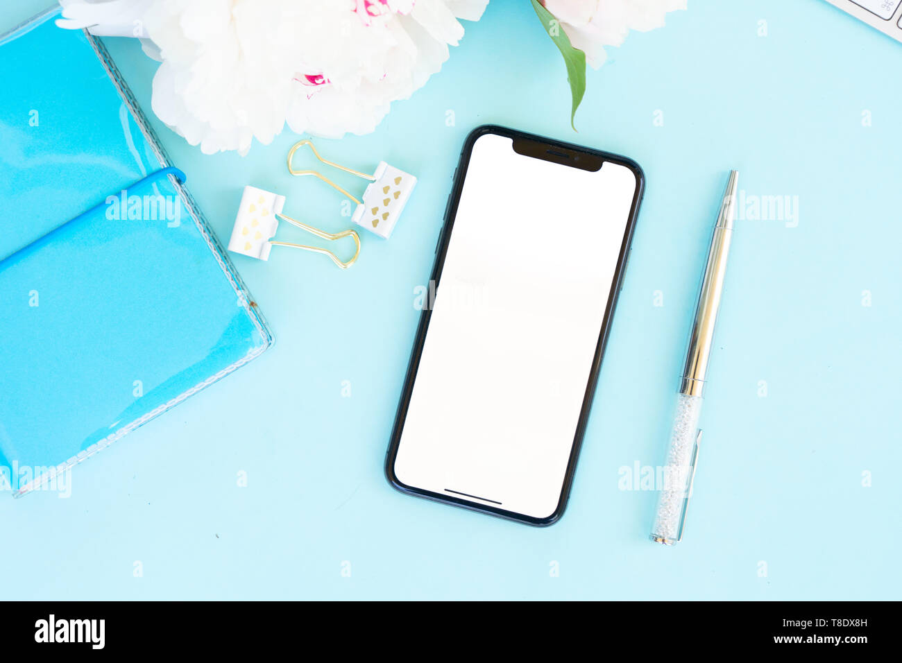 Home office desk with phone on blue Stock Photo - Alamy