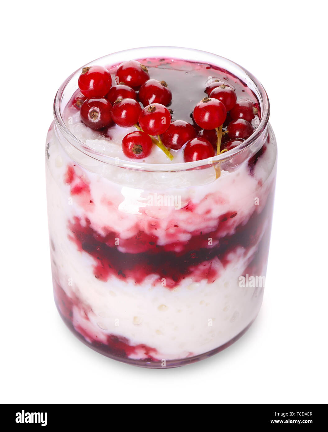 Glass jar with delicious rice pudding and currants on white background ...