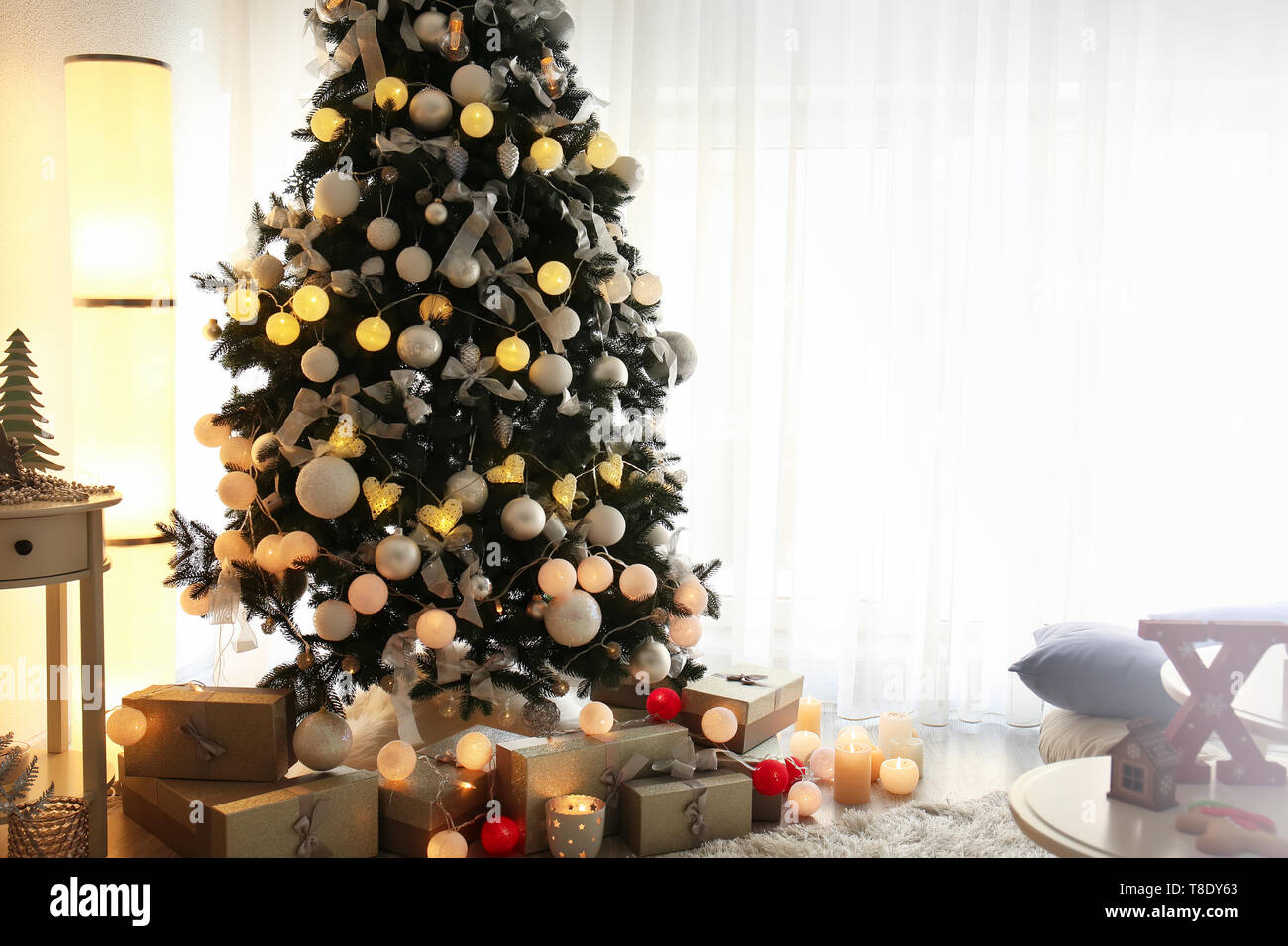 Beautiful decorated fir tree with gifts in room Stock Photo - Alamy