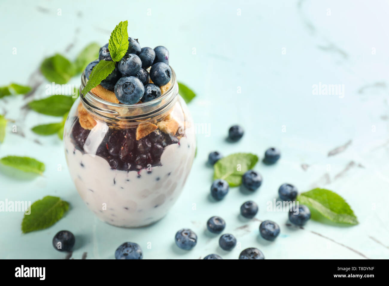 Glass jar with delicious blueberry dessert on light table Stock Photo ...