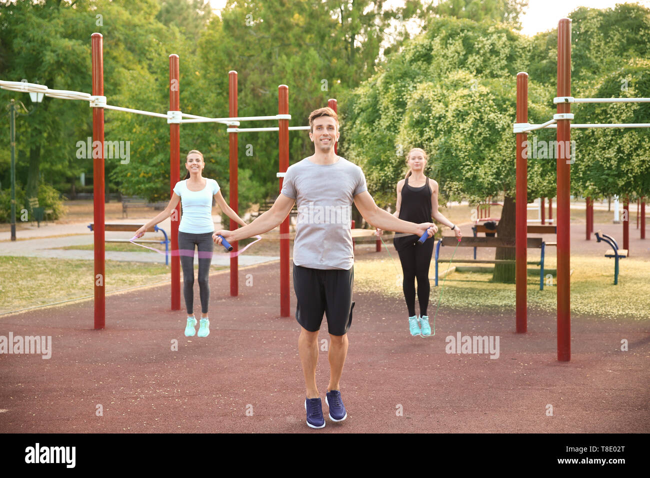 Group of sporty people jumping rope on athletic field outdoors Stock ...