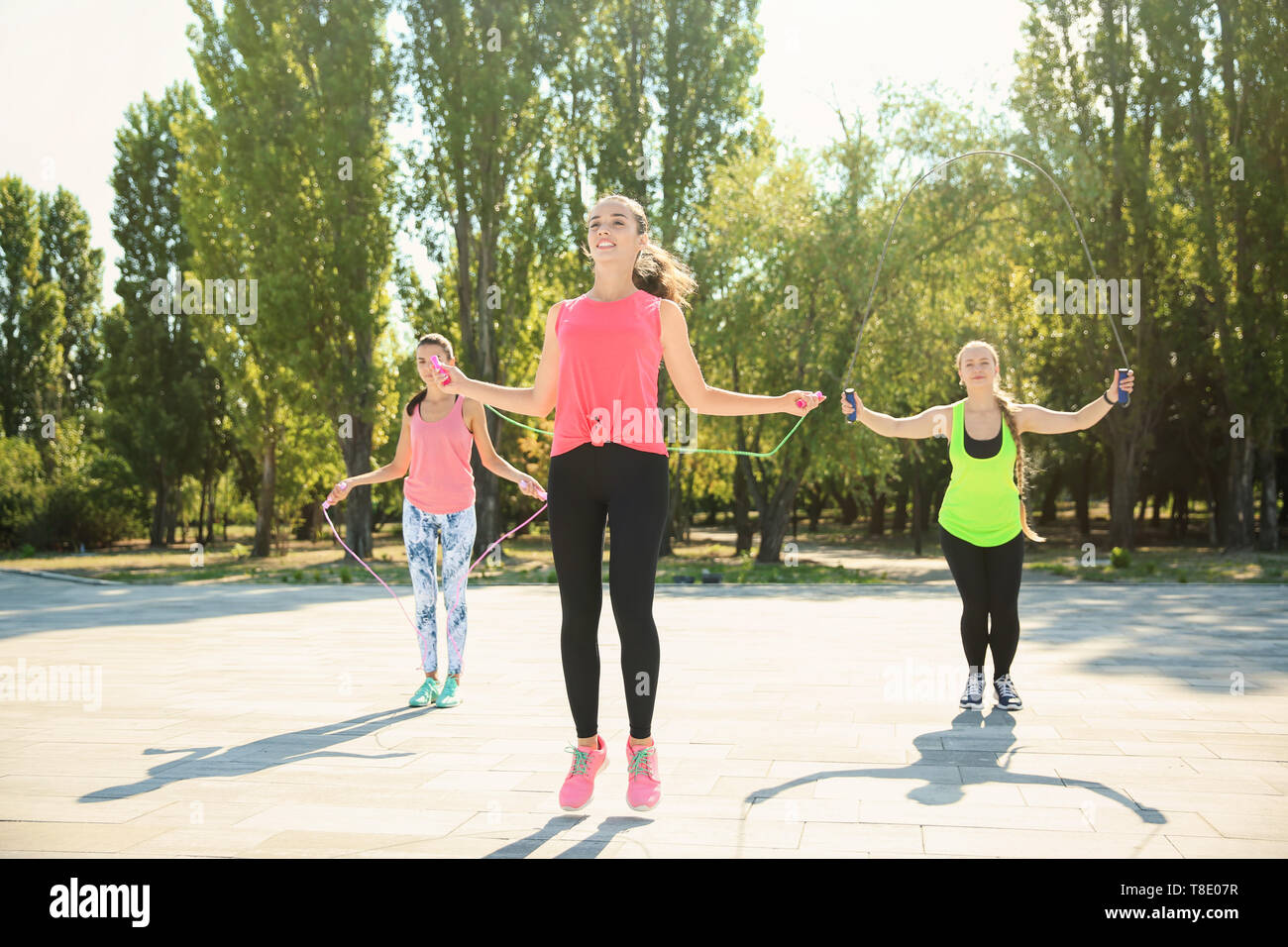 Group of sporty people jumping rope outdoors Stock Photo - Alamy