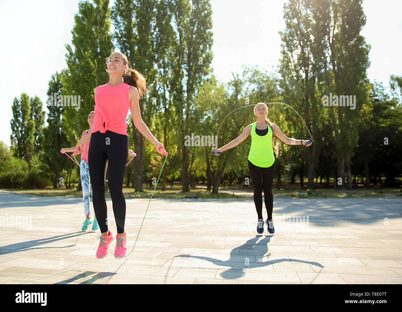 Group of sporty people jumping rope outdoors Stock Photo - Alamy